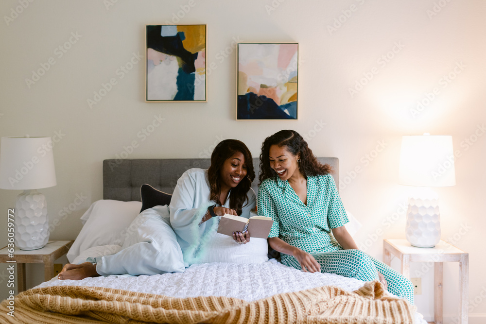 Girl friends reading together in bedroom Stock Photo | Adobe Stock