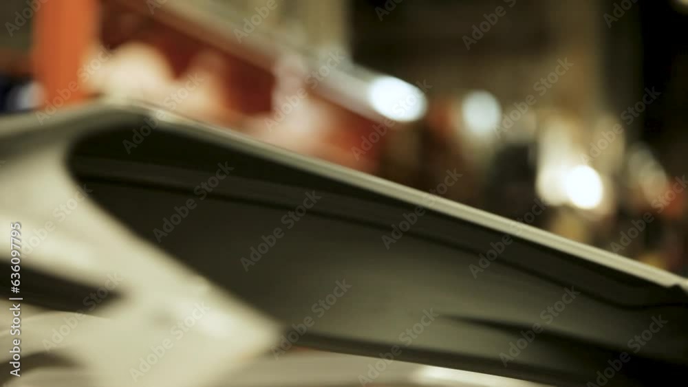 Vidéo Stock Through a static camera, a black robotic arm with a silver ...