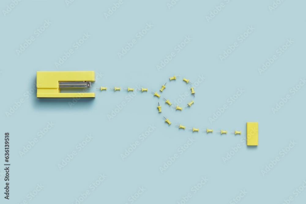 Stapler and eraser connected by yellow push pins. Stock-Foto | Adobe Stock