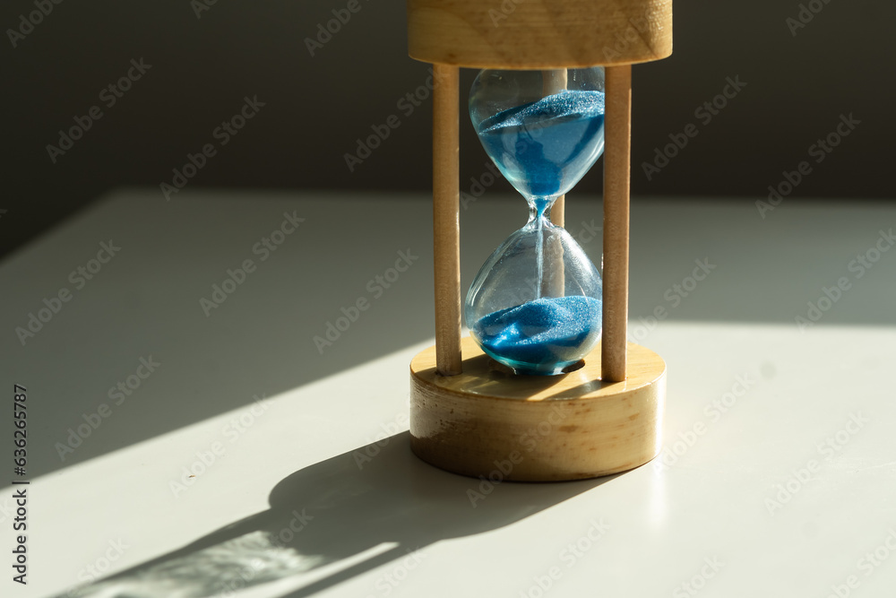 Old fashioned retro wooden hour glass clock with white sand standing on ...
