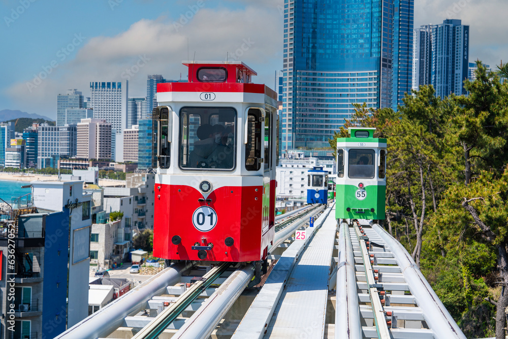 sky capsule train running on seaside railway tracks in Busan, Korea. It ...