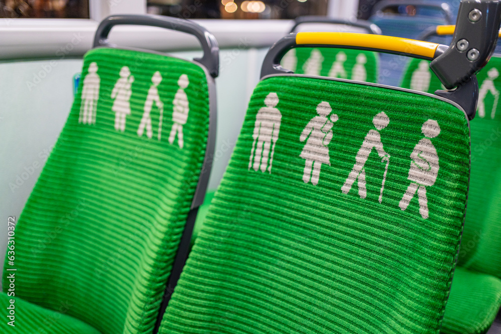 Green seats on a bus with printed signs for elderly, mother with young ...