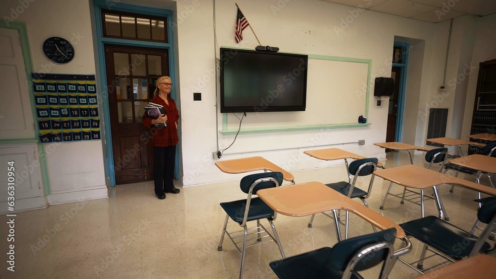 Happy teacher entering an empty classroom, turning lights, on ...