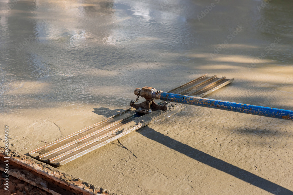 Workers leveling concreting for driveway on construction site using ...