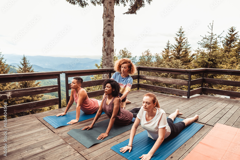 Young and diverse group of female friends doing yoga together on a ...