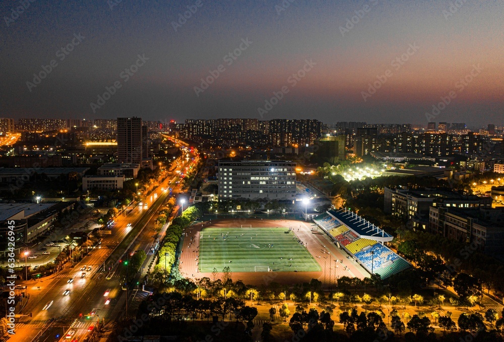 a night time photo with an outside soccer field and buildings Stock ...