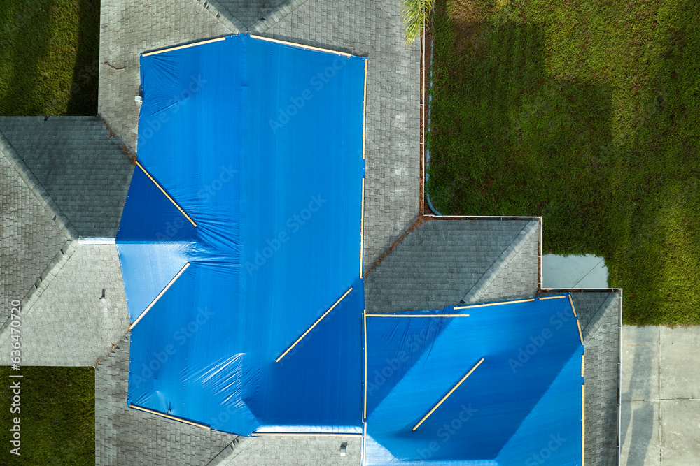 Top view of leaking house roof covered with protective tarp sheets ...
