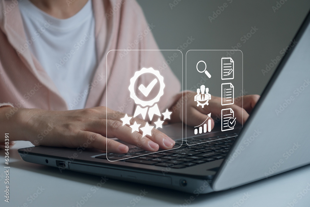 Businesswoman using laptop computer with quality assurance and document ...