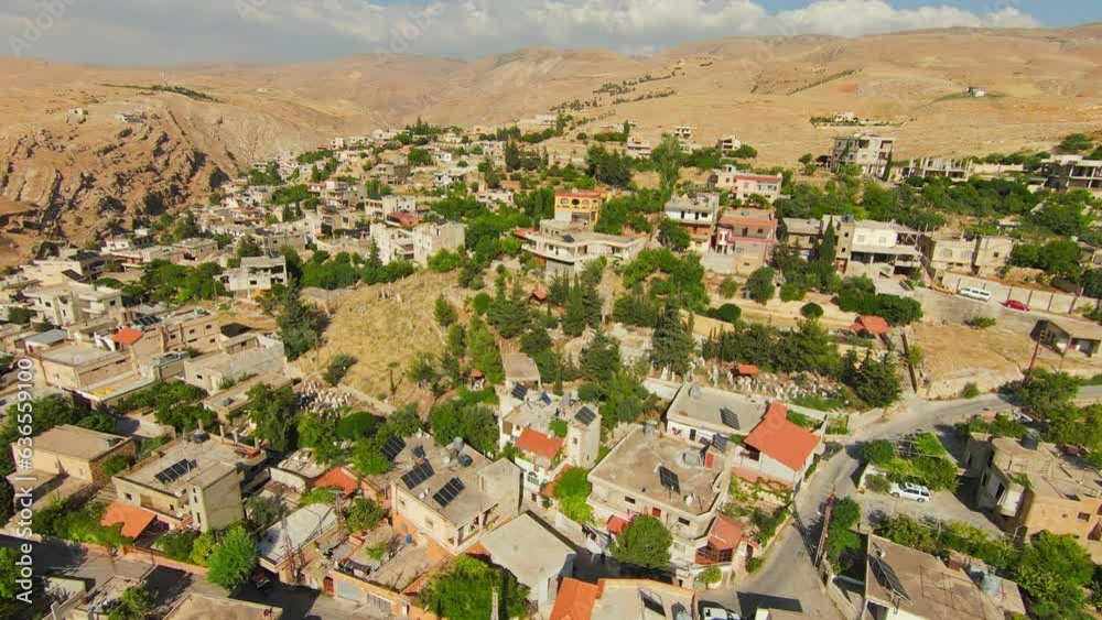 Soaring fpv immersive view above desert mountain boxed building town in ...