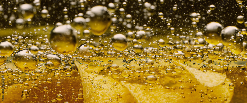 Deep fried potato chips under golden oil water. Frying rounded potatoes ...