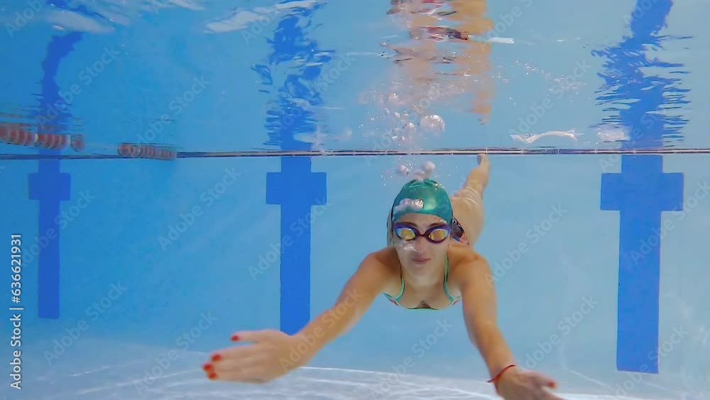 Woman athlete swims underwater in the pool. Slow motion of a female ...