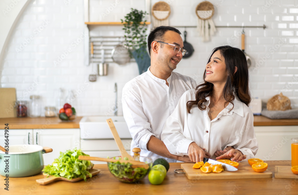 Young asian family couple having fun cooking and preparing cook vegan ...