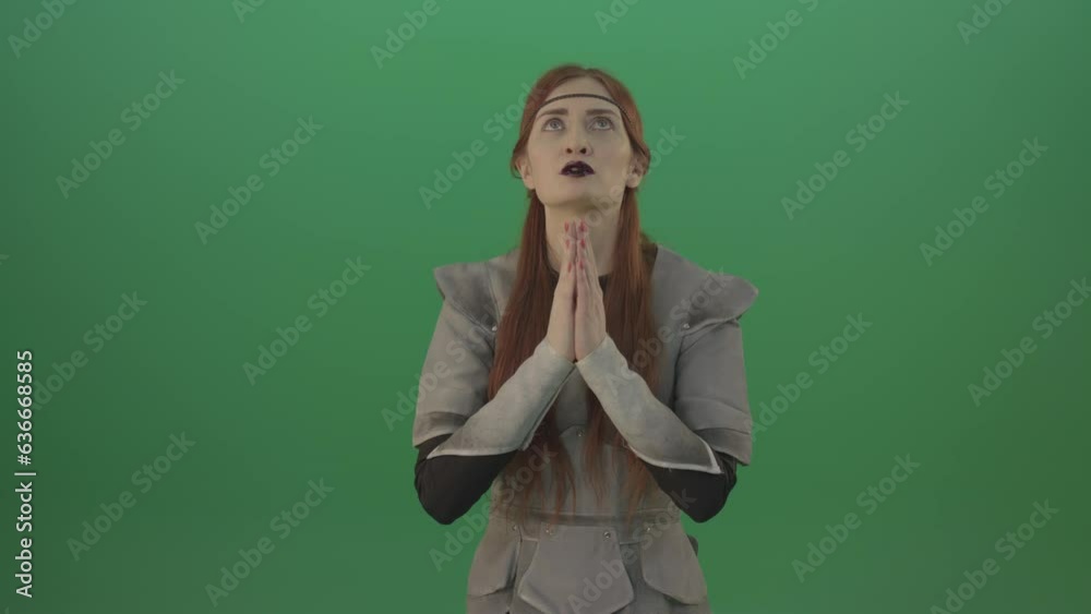 Red hair girl praying god in medieval warrior costume in green screen ...