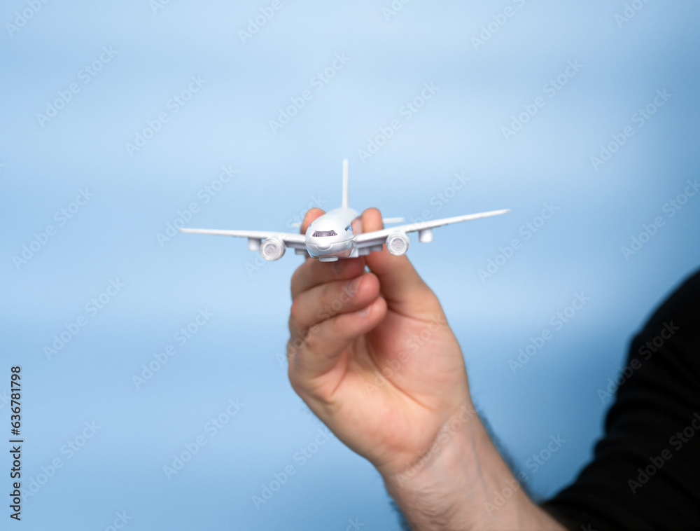 Vacation travel concept, a model of a passenger plane in a man's hand ...