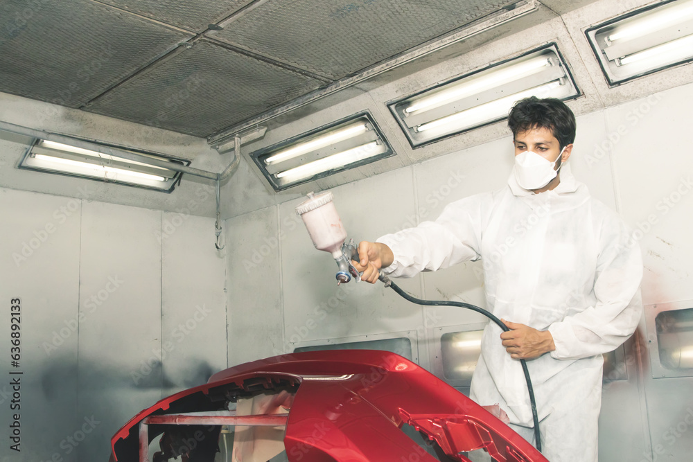 Automotive paint services : Male painter skilled using red spray paint ...