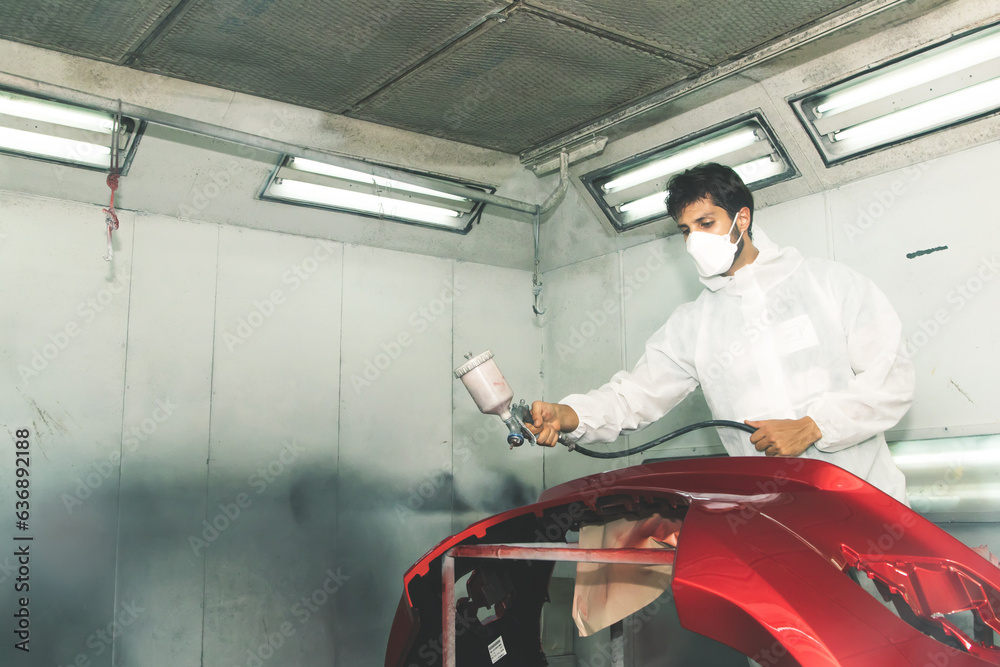 Automotive paint services : Male painter skilled using red spray paint ...