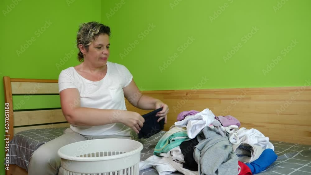 The woman sorts the clothes, and throws the old and worn ones into the ...