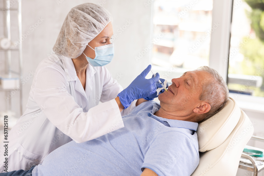 Female doctor conducting face revitalization procedure for old man ...
