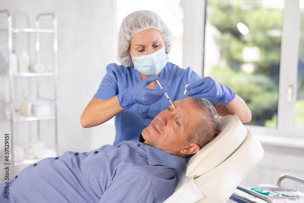 Female doctor conducting face revitalization procedure for old man ...