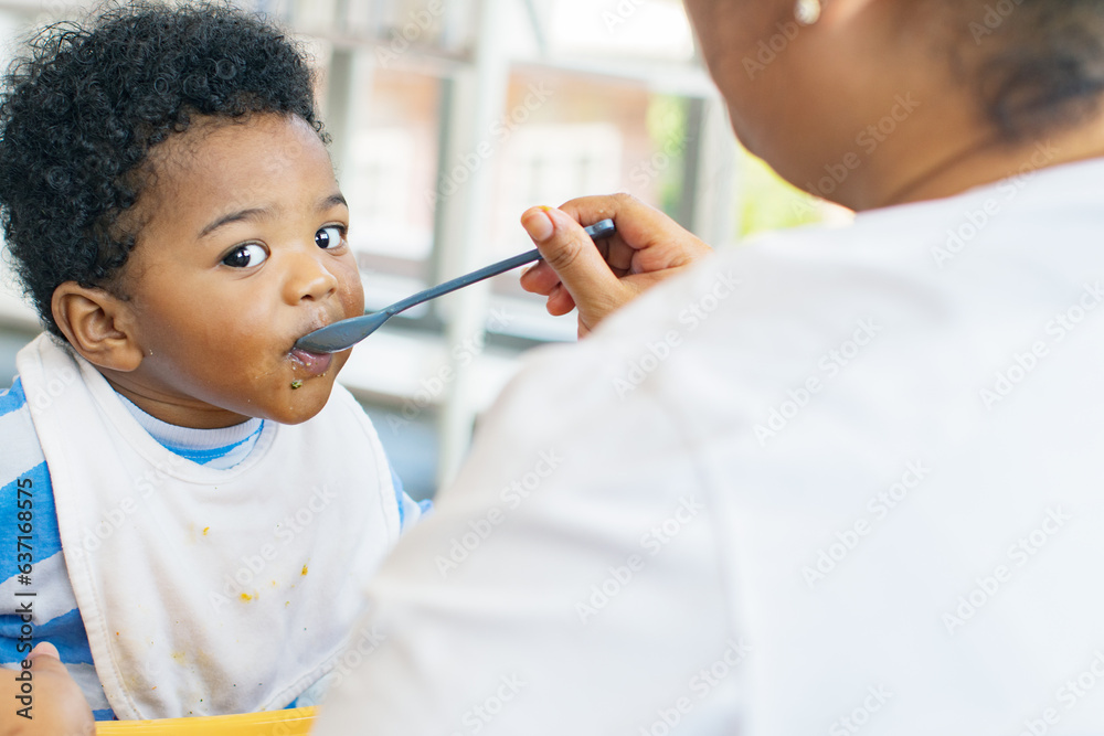 Mother raising take care an African-American Thai son feeds him simple ...
