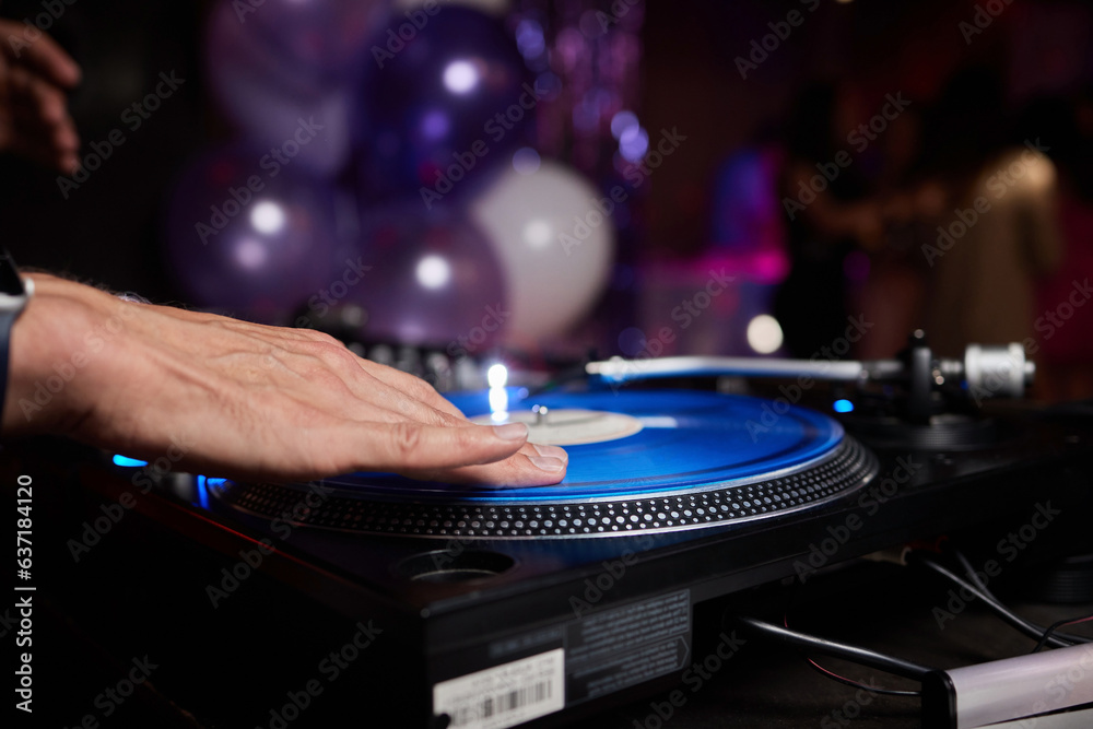 DJ behind the decks in a nightclub. DJ spinning plate. people dancing ...