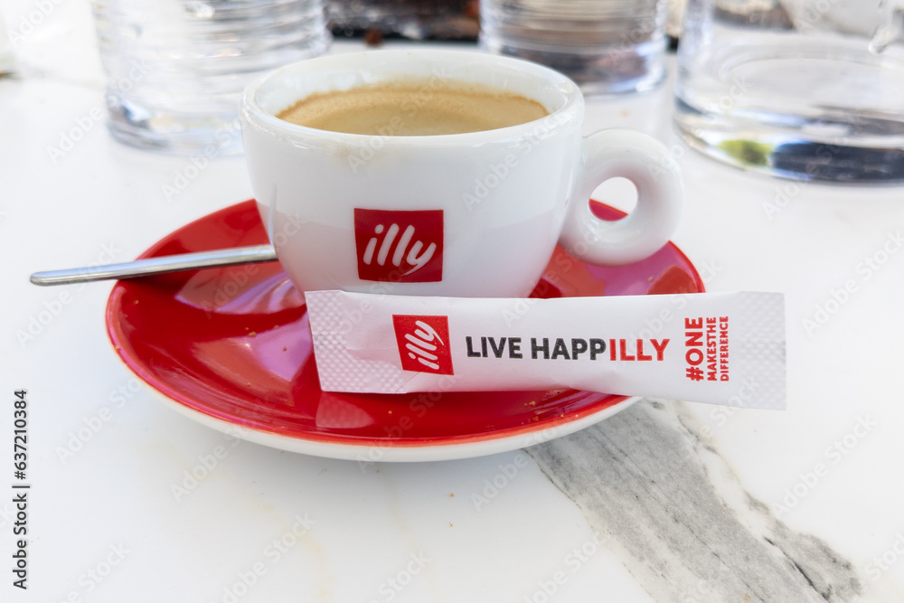 Illy coffee shop red sign logo cafe Italian coffee makers text brand on cup with white sugar bag ...