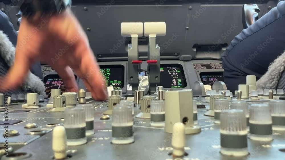 Low angle view inside a jet cockpit of the engine control panel while ...