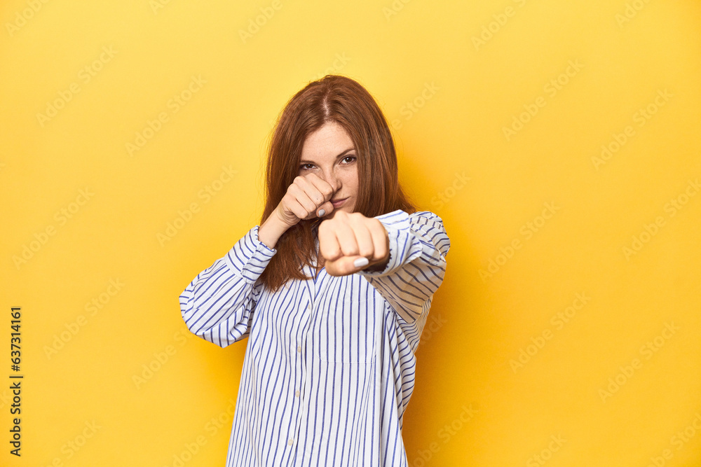Business-dressed redhead, formal studio shot throwing a punch, anger ...