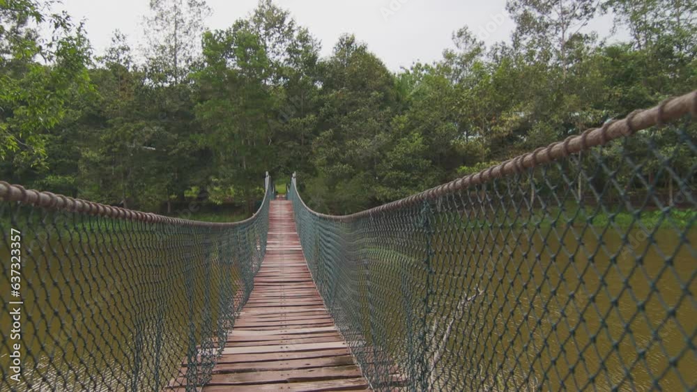 Experience the adventure as you traverse a rope and wooden foot bridge ...