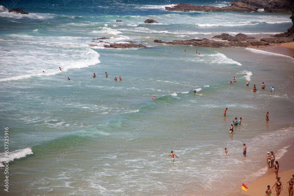 Vibrant scene at Porto Covo's expansive beach: bathers enjoying the ...