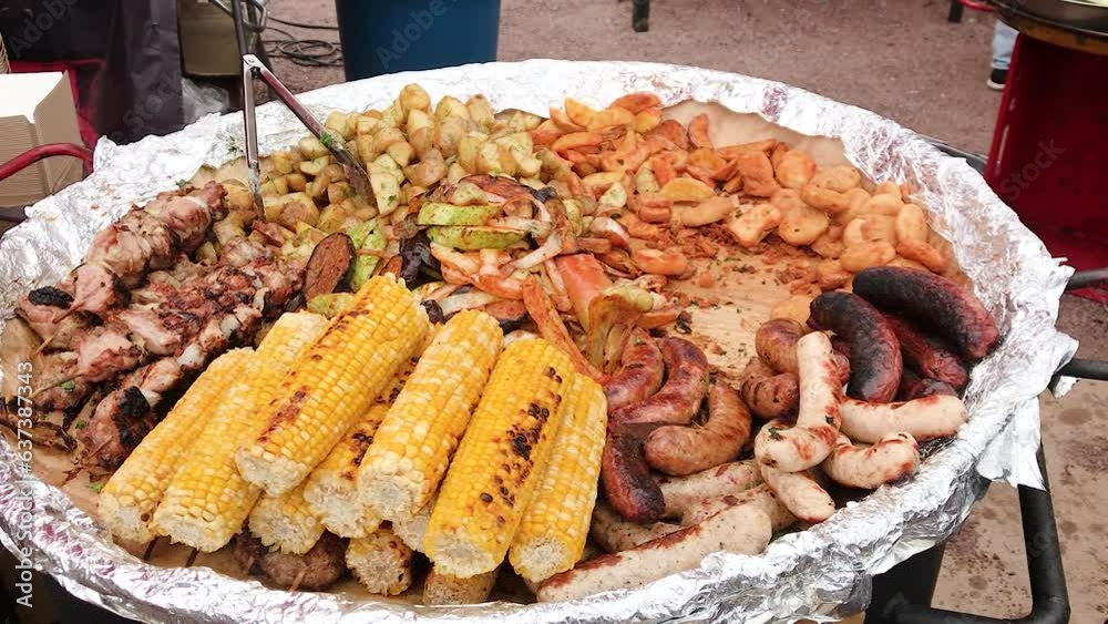 cauldron barbecue with food corn sausages potatoes zucchini chicken ...