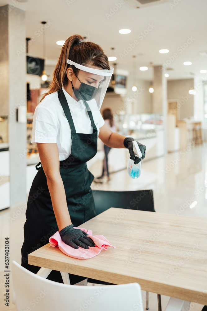 Beautiful woman working bakery or fast food restaurant. She is cleaning ...
