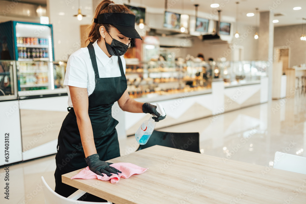 Beautiful woman working bakery or fast food restaurant. She is cleaning ...