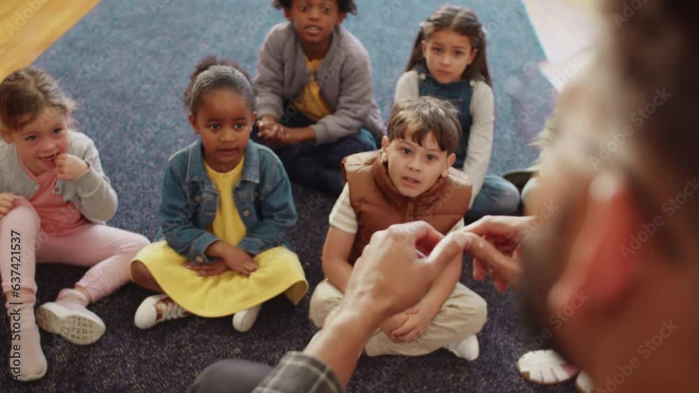 First grade teacher teaching a group of young children the alphabet ...