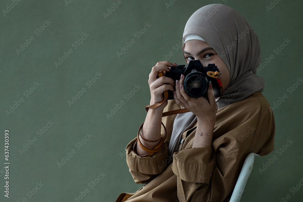 Pretty Muslim girl in hijab holding vintage camera over background in ...