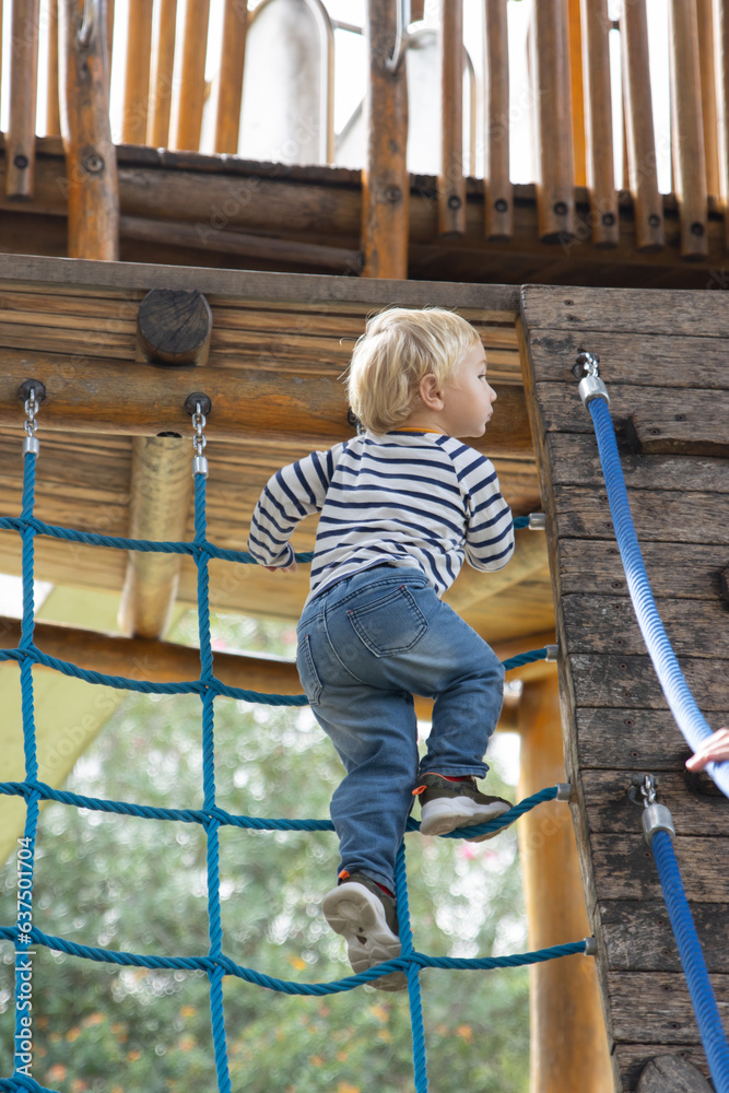Little boy climbing up a rope ladder on the playground Stock Photo ...