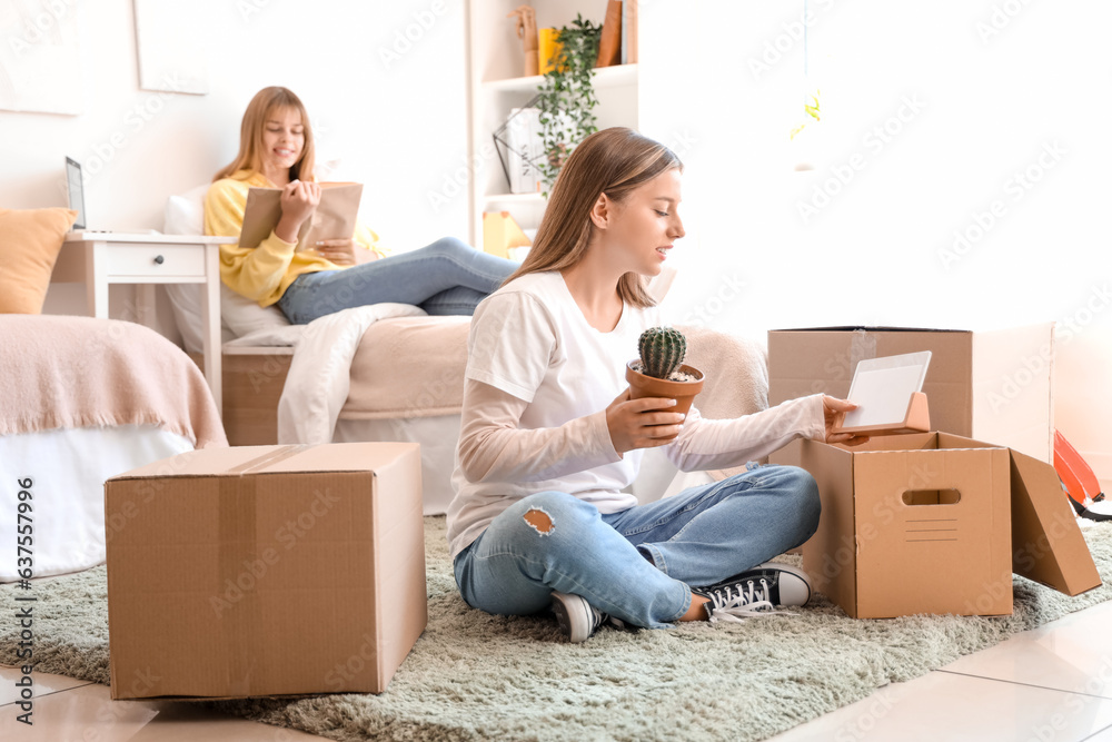 Female student unpacking things in dorm room on moving day Stock Photo ...