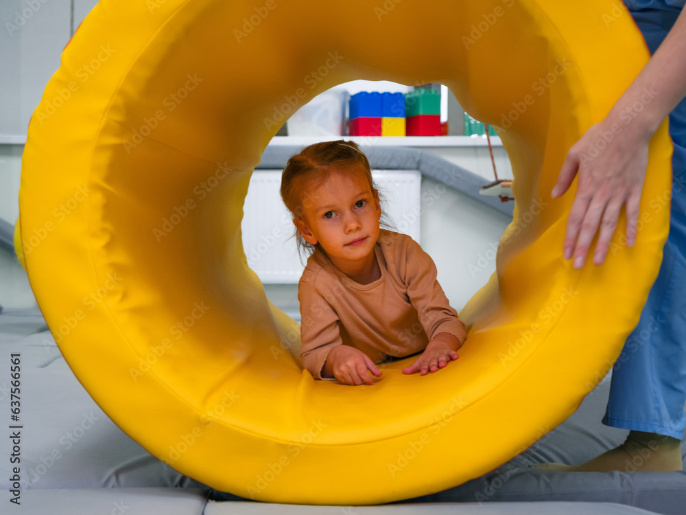 Kid girl rotation in roller tonnel during sensory integration session ...