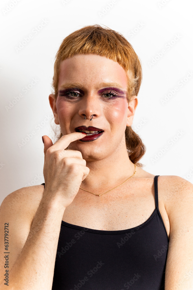 Vertical photo of a non-binary redhead is posing on a white background ...