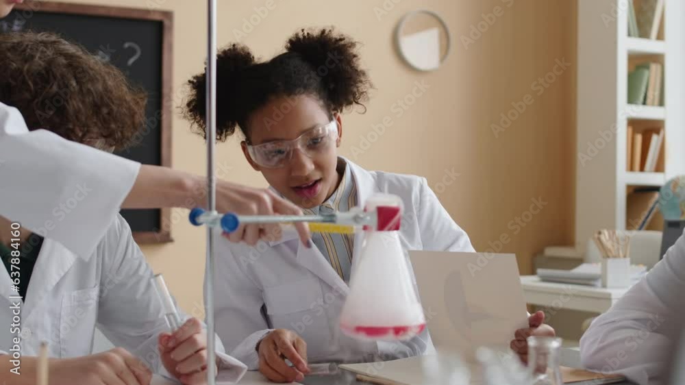 Waist up of preteen African American schoolgirl wearing safety glasses ...