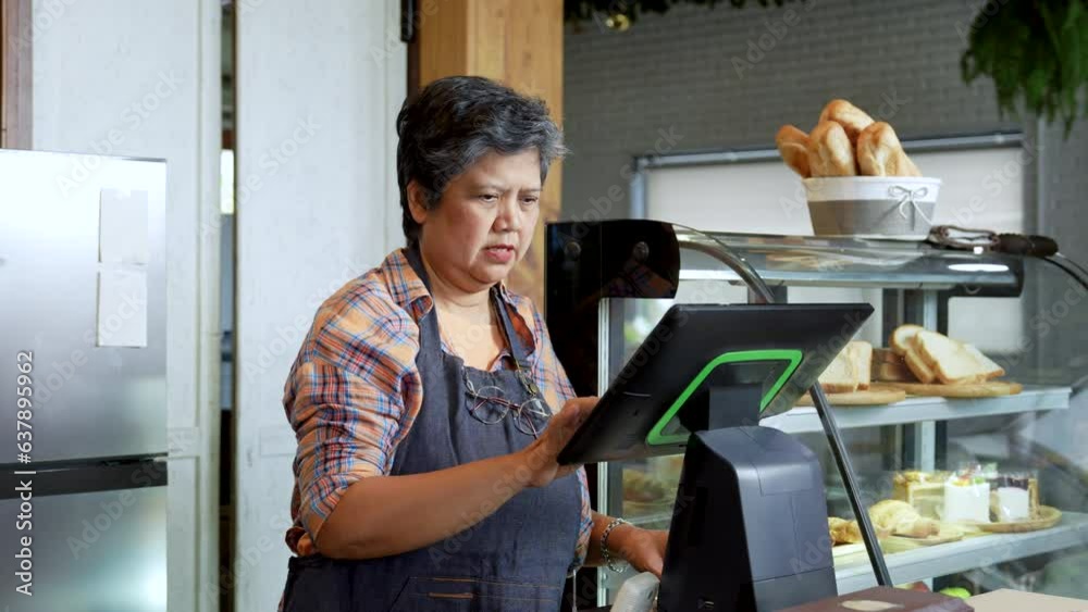 Busy Asian elderly woman barista using touch screen cashier for a new ...