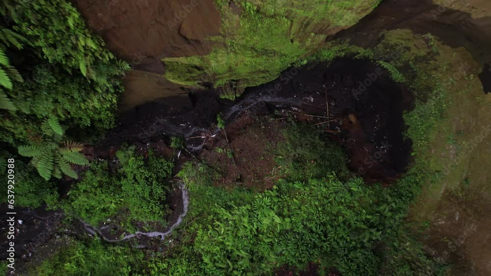 Camera fly up, showing bottom and vertical slopes of deep ravine. The ...
