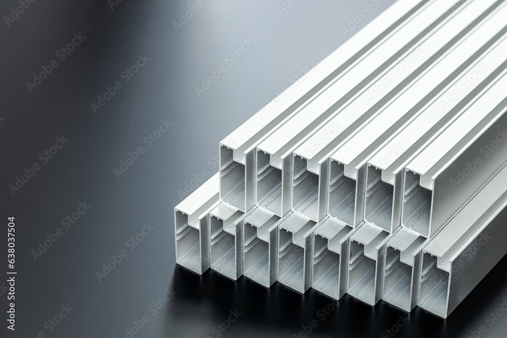 Aluminum profiles on a beautiful black background, rows of aluminum ...