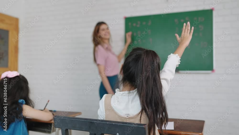 Kids raising hands while teacher explaining the lesson functioning in ...