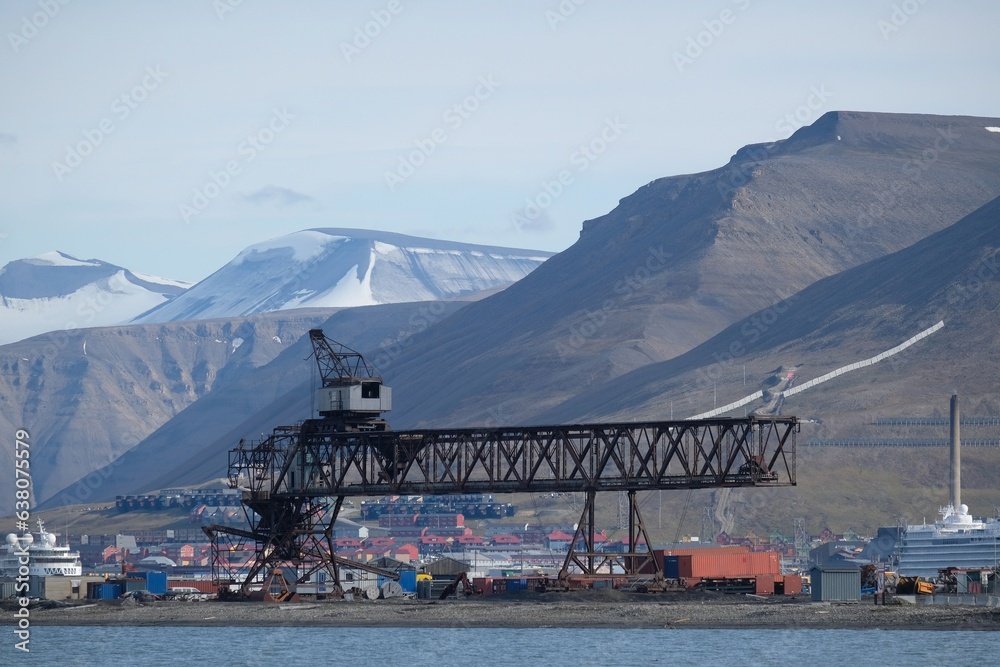 Panorama of Longyearbyen with port and container crane on coast. Former ...