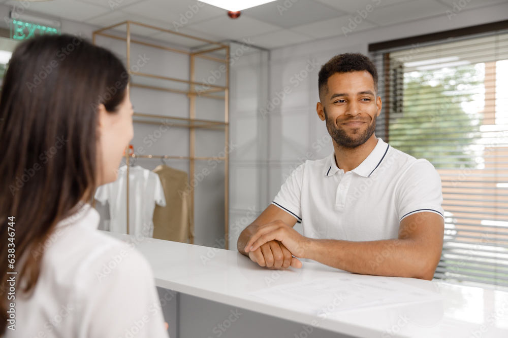 Charismatic man closeup to the camera at reception desk in the modern ...