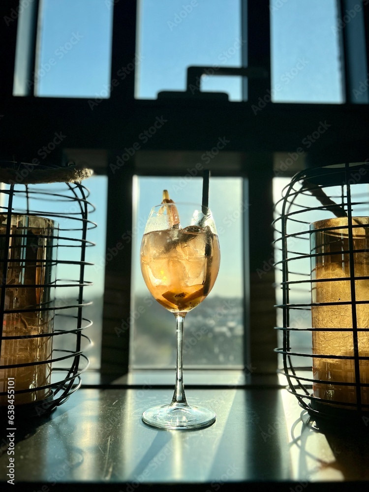 Aperol cocktail in a glass on a table in a cafe with shadows from of ...