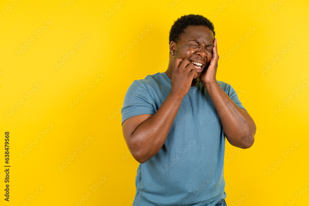 Doleful desperate crying handsome African American standing over yellow ...