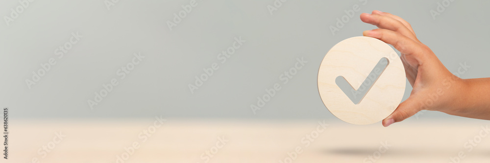 Hand holding check mark icon, banner with wooden check mark icon in ...