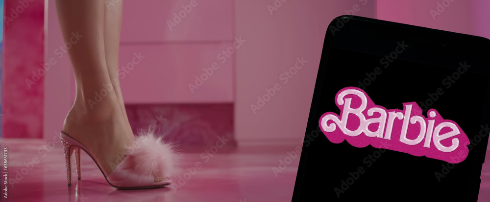 The Barbie logo is displayed on the screen of a smartphone with part of ...